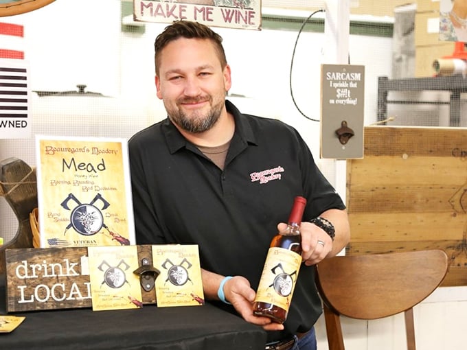 Make Me Wine isn't just a sign—it's a life philosophy for this mead vendor, whose smile suggests he's found the secret to turning honey into liquid joy.