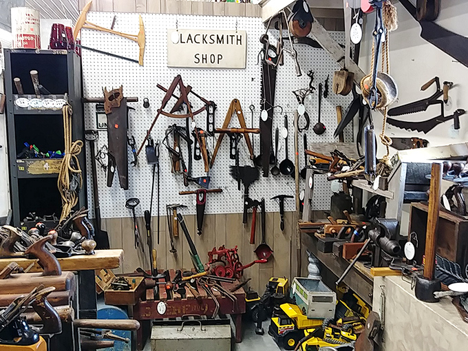 The blacksmith shop display—where modern DIYers come to feel thoroughly inadequate next to tools that built America one swing at a time.