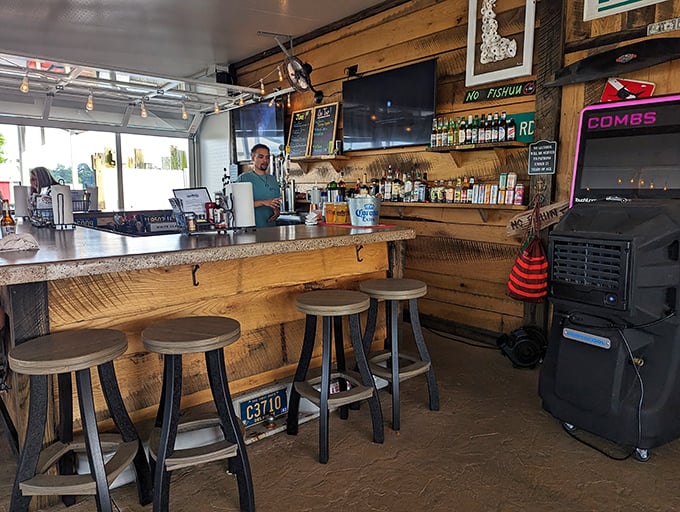 The bar area speaks the universal language of coastal comfort – reclaimed wood, license plates, and the promise of cold drinks after a hot day.