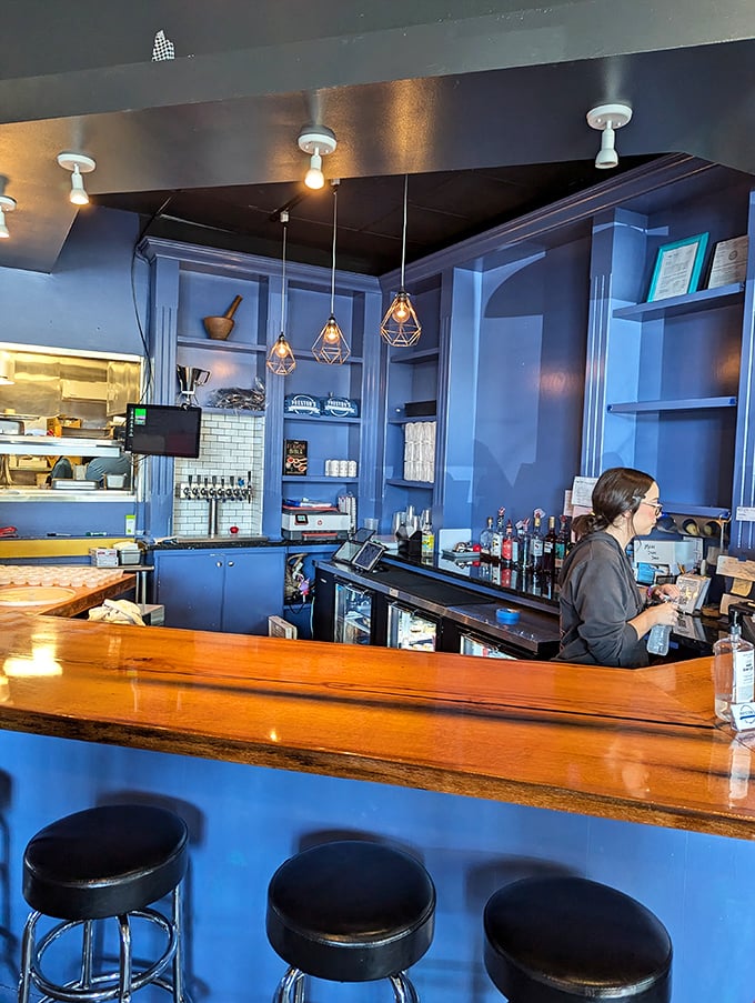 The warm wood bar top contrasts beautifully with cool blue surroundings. Those pendant lights aren't just illuminating space—they're spotlighting your next great meal.