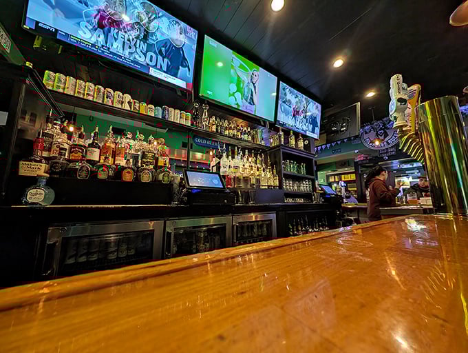 Behind this bar lies liquid happiness – an impressive array of spirits bathed in the glow of multiple screens showing the game.