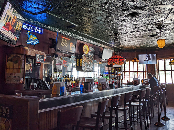 The bar area feels frozen in time—in the best possible way. Vintage lighting and well-worn wood create the perfect spot for contemplating your next hot dog order.