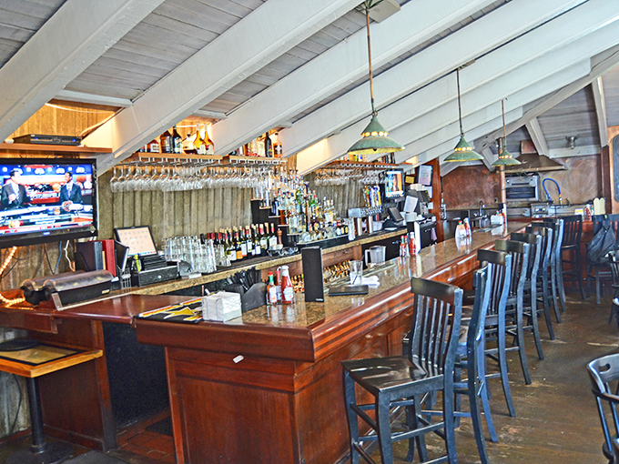 A bar that invites lingering conversations and "just one more" local wine while suspended glassware catches the coastal light like liquid prisms.