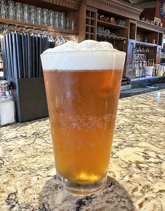 Golden amber beer with a perfect head—the kind that makes you pause for appreciation before taking that first, satisfying sip.