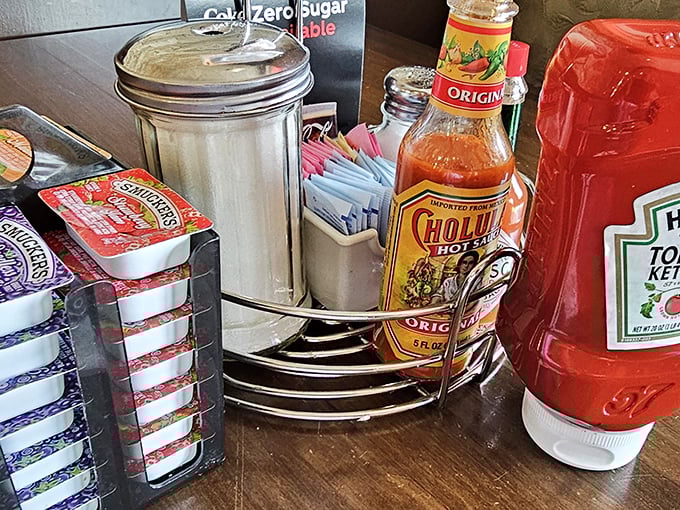 The condiment caddy—that unsung hero of breakfast customization where hot sauce dreams and ketchup fantasies come true for the discerning diner.