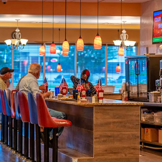 The counter seating, with its warm pendant lighting, offers front-row tickets to the culinary show and prime real estate for solo diners.