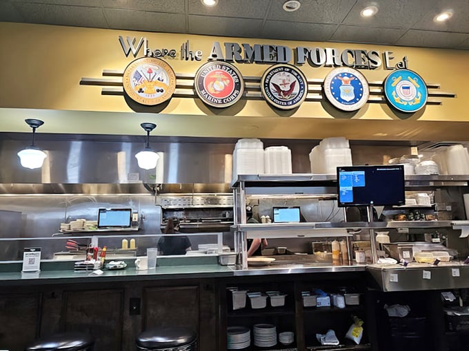 The open kitchen showcases military pride above the pass. Here, food preparation is both art and honorable service.