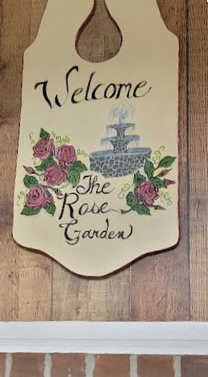 The handcrafted welcome sign with painted roses and fountain tells you everything you need to know—this place values tradition, beauty, and making you feel at home.