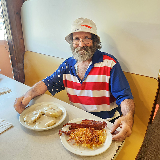 A patron enjoying what appears to be the full Hyde's experience—biscuits and gravy, eggs, bacon, and the satisfaction of knowing some things never change.