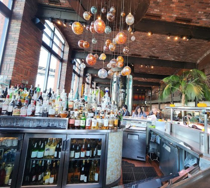 The bar doesn't just serve drinks—it creates liquid memories under a constellation of hanging glass orbs that would make Galileo thirsty.