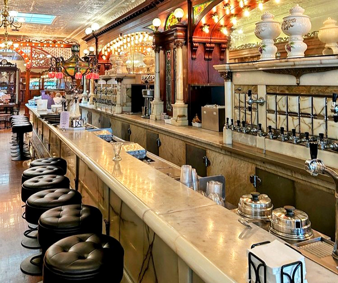 The soda fountain counter – where magic happens daily as syrups, sodas, and ice cream combine in a choreographed dance of deliciousness.