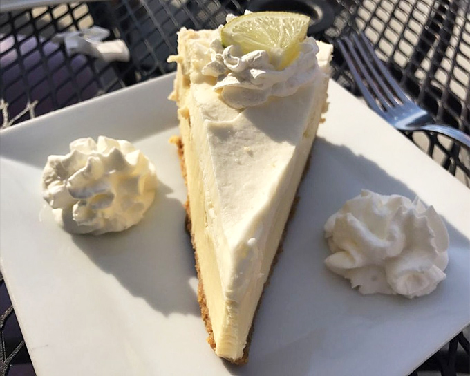 Key lime pie that balances sweet and tart like a high-wire artist. Those dollops of whipped cream aren't decoration—they're essential supporting players in this citrus symphony.