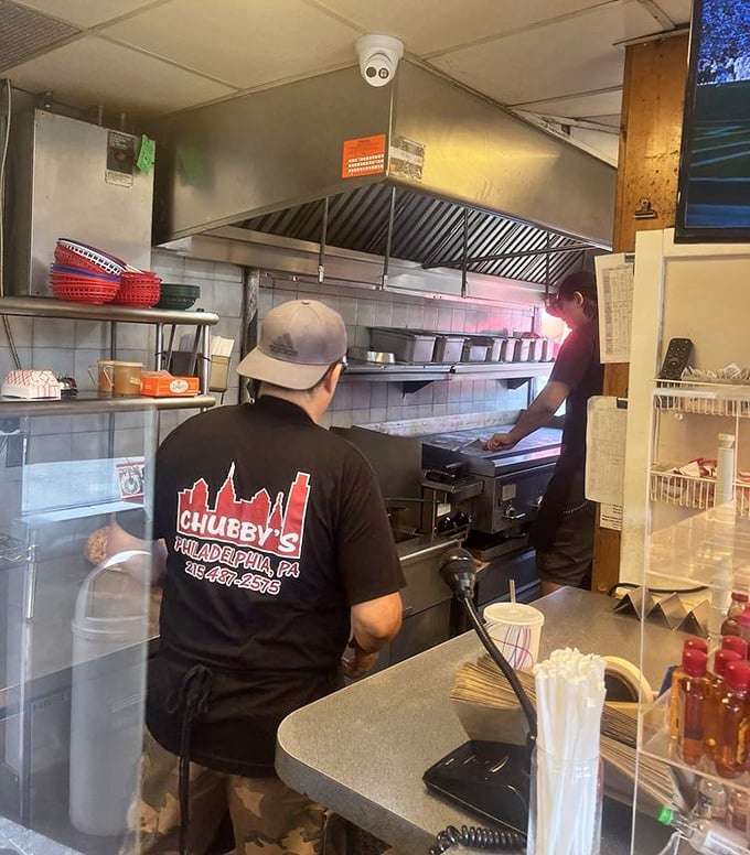 The kitchen—hallowed ground where the magic happens. Those hands have probably made more cheesesteaks than most of us have had hot meals.