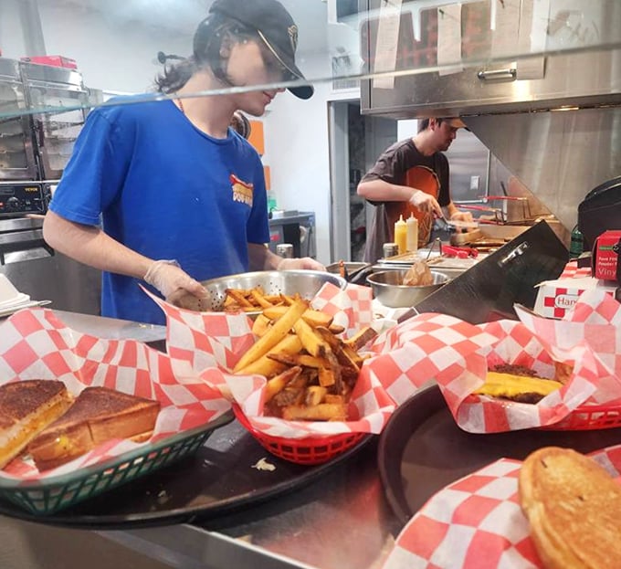 The kitchen ballet – where hot dog dreams become reality. Those hands have likely prepared thousands of meals, each with the same care as the first.