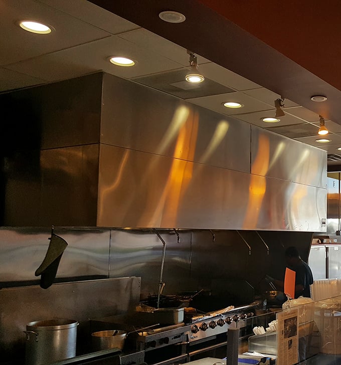 A glimpse into the kitchen reveals the serious hardware behind serious flavor. That's not a stove—it's a flavor laboratory.