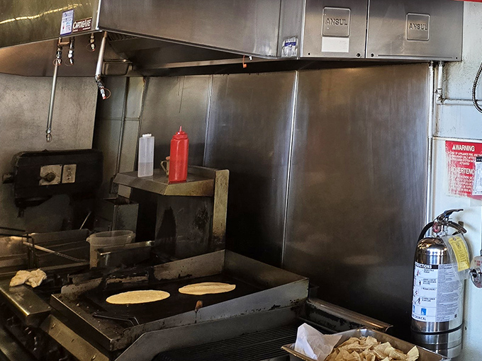 Where the magic happens—a glimpse into the kitchen's choreography. That flat-top grill has seen more action than a Hollywood stuntman, and the results are equally impressive.