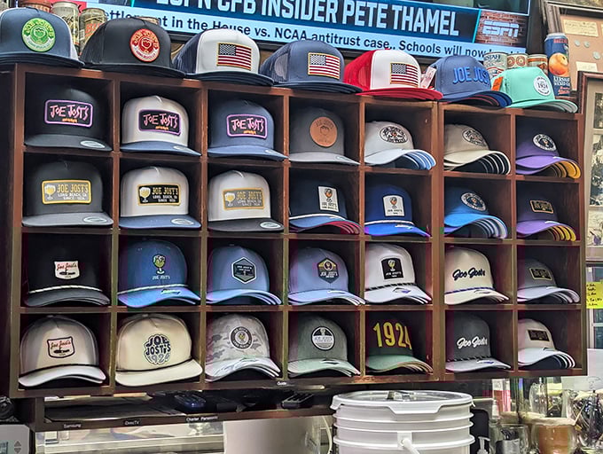 The hat wall at Joe Jost's isn't just merchandise—it's a colorful museum of loyalty where regulars proudly display their allegiance to this Long Beach institution.