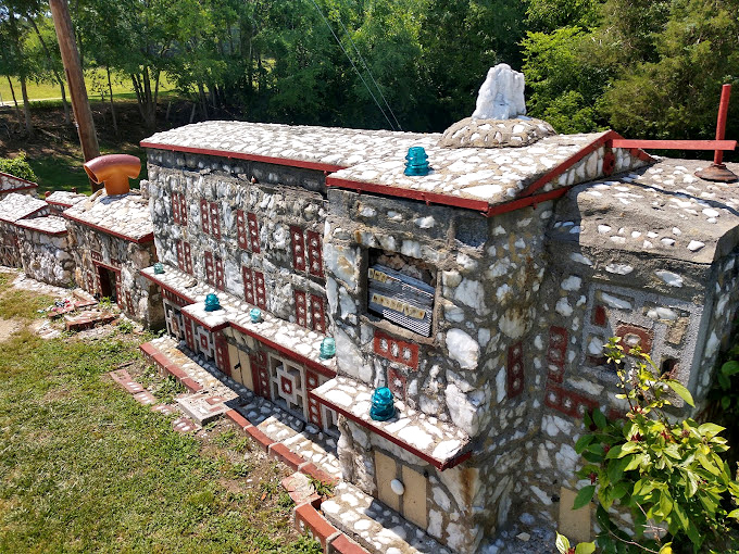 Architectural details that would impress at any scale. The blue glass insulators add unexpected pops of color among the stone and red trim.