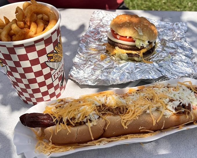 The holy trinity of roadside dining—crispy onion rings, a loaded chili dog, and a burger that makes fast food chains weep with inadequacy.