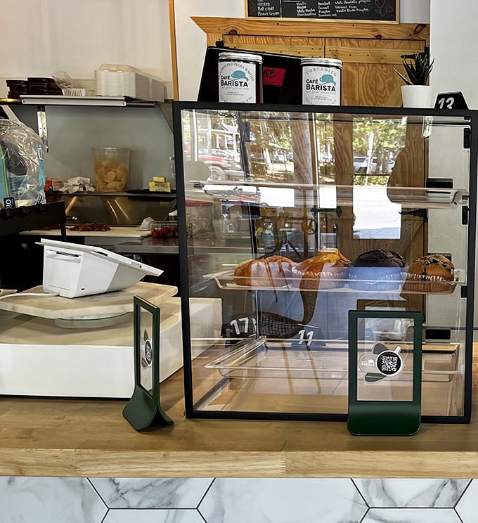 The pastry case – where morning intentions to "just have coffee" go to die amid tempting croissants and freshly baked treats.