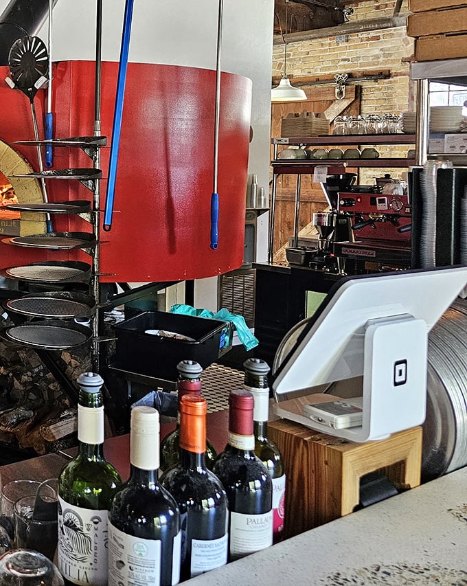 Where pizza magic happens. The gleaming counter, stacked boxes, and that glorious red oven in the background—this is pizza headquarters.