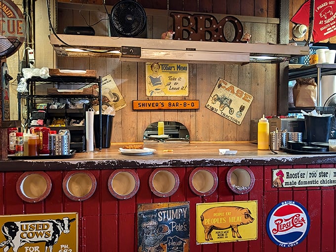 The counter's vintage signs and condiment bottles aren't decoration—they're artifacts from the museum of authentic barbecue culture.