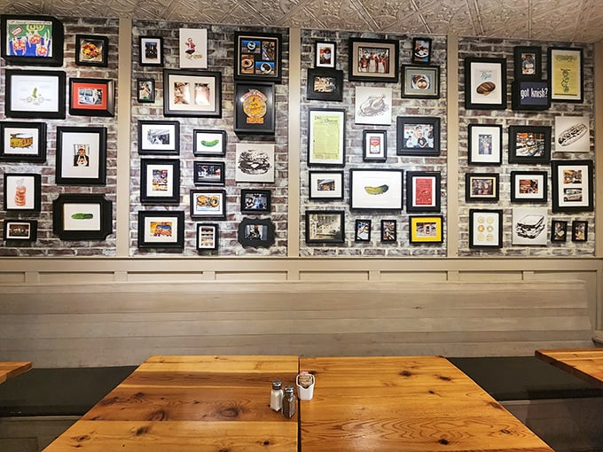The wall of framed art isn't just decoration—it's a visual history of deli culture and sandwich appreciation. Each frame tells a story of culinary devotion.