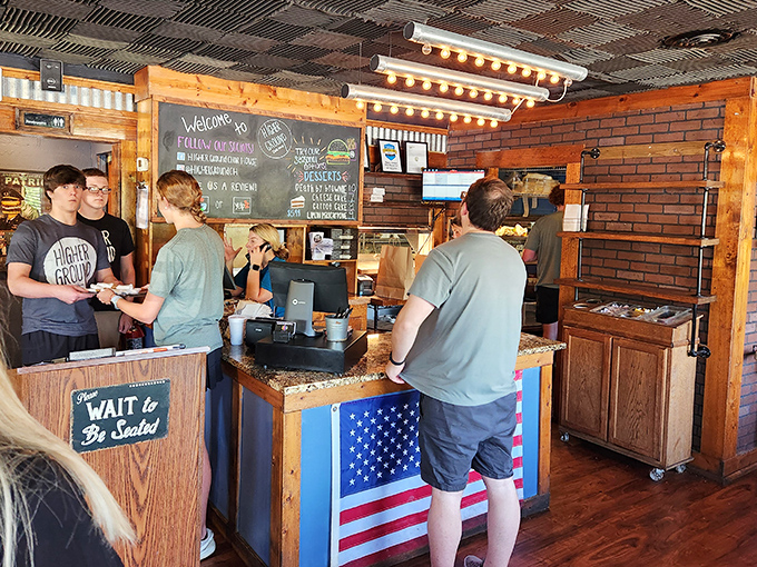 The ordering counter says it all – patriotic, welcoming, and with that "Wait to Be Seated" sign that promises proper hospitality.