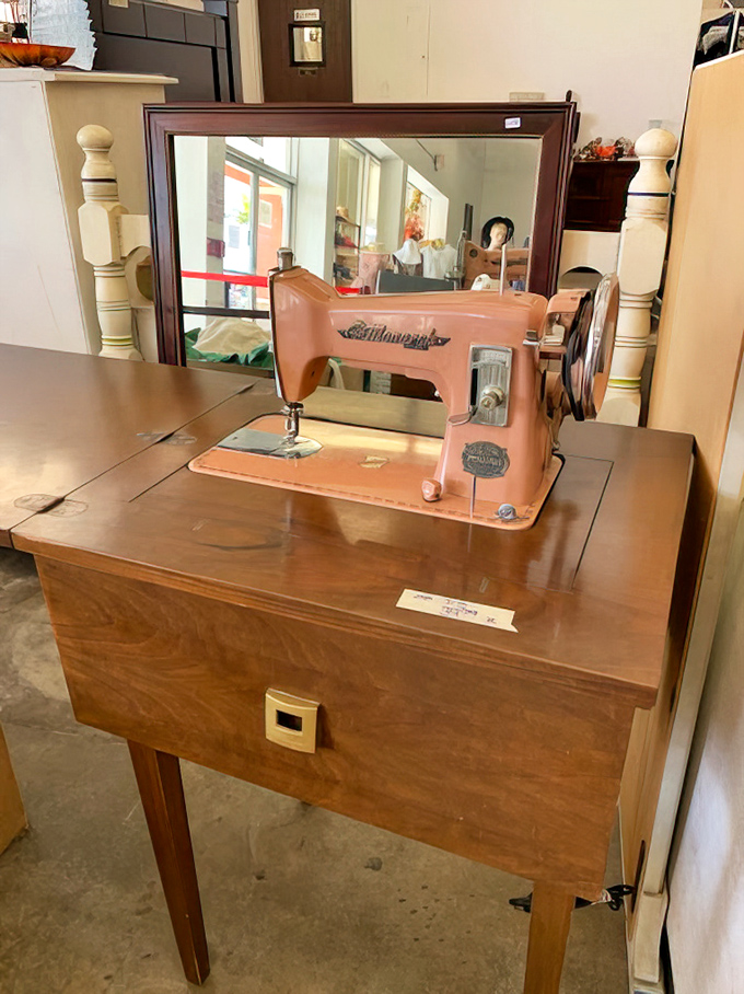 This pink Kenmore sewing machine perched atop its wooden throne isn't just vintage—it's a mechanical time capsule of handmade history.