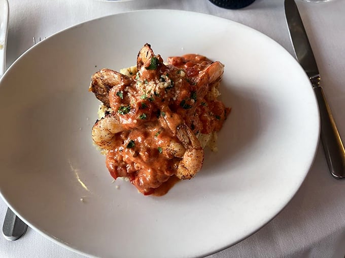 These shrimp aren't just resting on their grits—they're lounging luxuriously like they've checked into a five-star resort of creamy deliciousness.