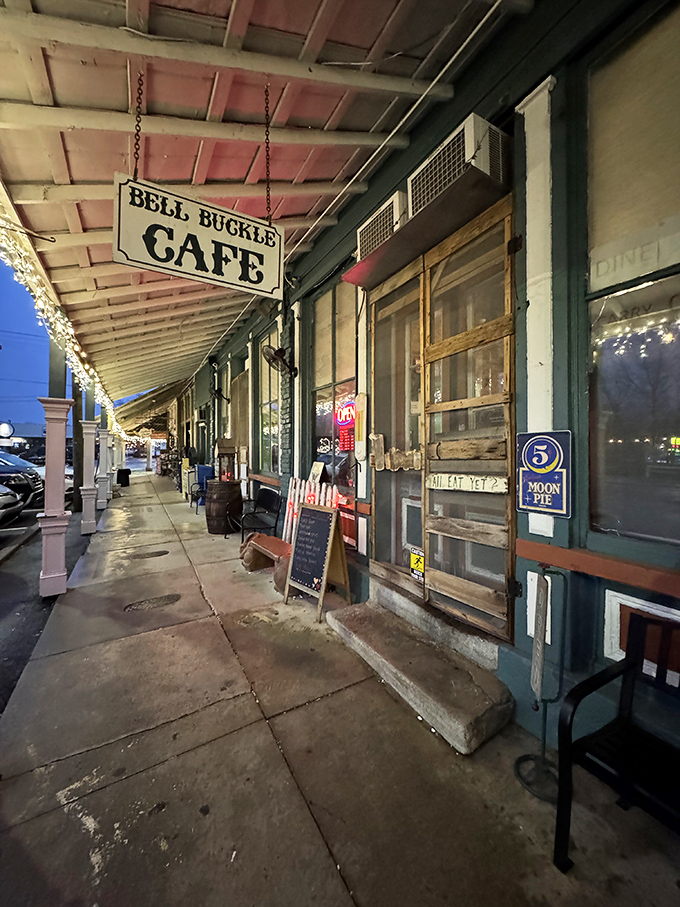 Night falls softly on Bell Buckle's sidewalks, where the café's hanging sign swings gently and a Moon Pie sign hints at sweet traditions.