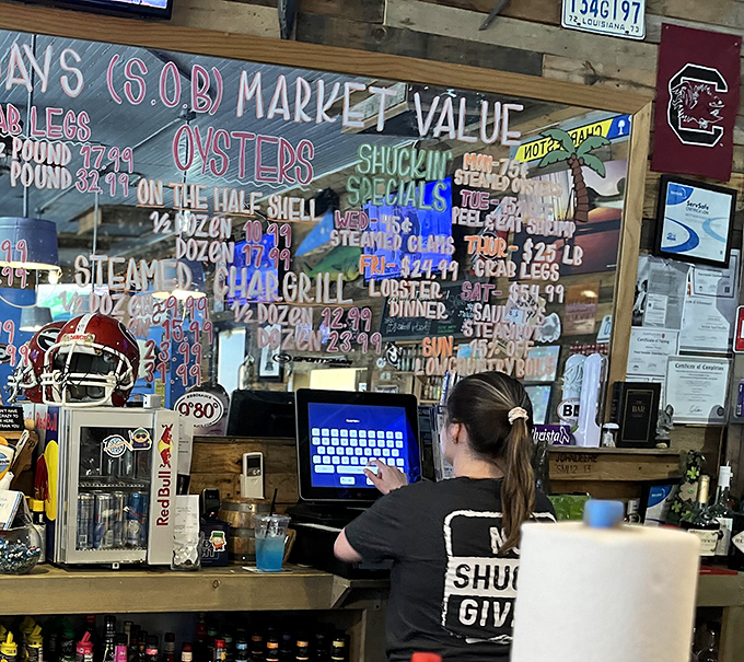 The transparent menu board showcases daily specials and market prices – seafood math at its most delicious.