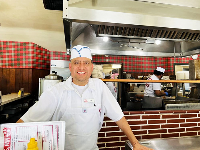The white paper hat isn't just tradition—it's a crown for burger royalty. These culinary craftsmen have forgotten more about burgers than most chefs will ever know.