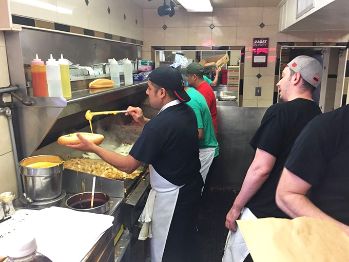The choreography behind the counter is mesmerizing – these sandwich artists have elevated the cheesesteak assembly to performance art.