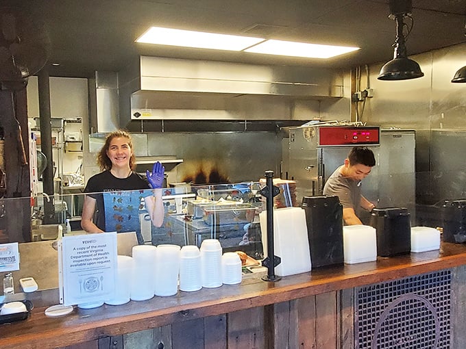 Behind the counter, where the magic happens. Those gloves aren't just blue—they're the color of barbecue authority.