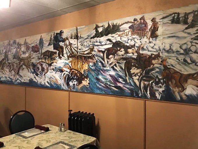 A dramatic mural depicting northwoods heritage—dogs, sleds, and snow creating the perfect backdrop for warm conversations over hot food.