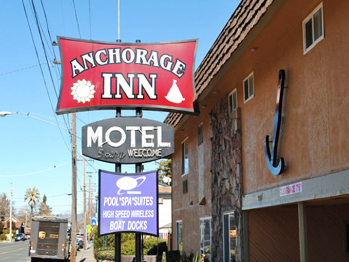 The Anchorage Inn's vintage sign promises boat docks and pool spas—a throwback to vacations when "amenities" meant actual fun, not tiny shampoo bottles.