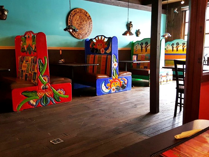 Those hand-painted booths aren't just seating—they're portals to a Mexican village where color is the main language.