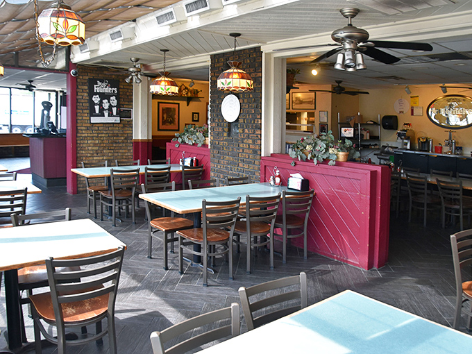 Red dividers and exposed brick create dining zones that feel intimate yet connected, like neighborhoods in a delicious little pizza city.