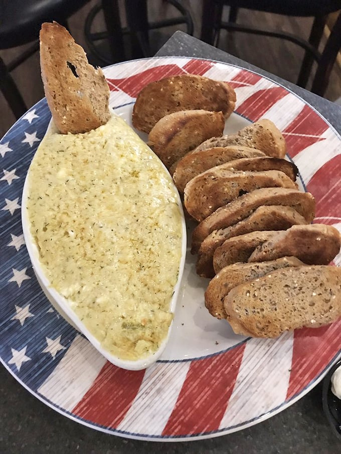 An artichoke dip that's clearly running for office on the "Creamy & Delicious" ticket, served with what appears to be house-made bread for dipping.