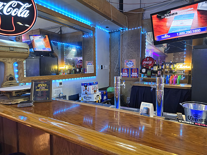 The bar glows with blue lights and promises of cold beverages, creating that perfect neighborhood hangout atmosphere.