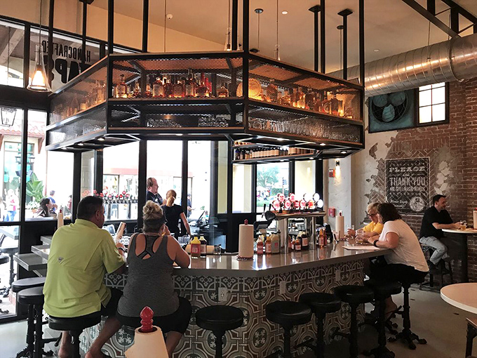 The bar—where bourbon bottles gleam like trophies and the industrial-chic design says, "Yes, barbecue can be sophisticated."
