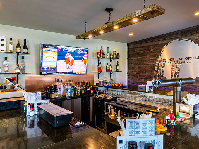 The bar area strikes that perfect balance—enough bottles to promise adventure, enough taps to ensure happiness, and TVs strategically placed for sports emergencies.