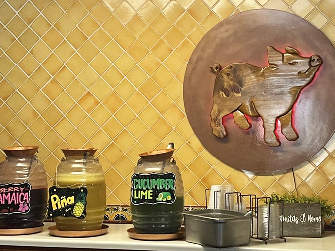 Handcrafted beverages in charming jars beneath the watchful eye of the El Momo pig. These aren't just drinks—they're liquid companions for your carnitas journey.