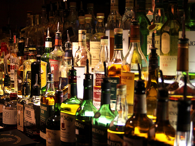 The backlit bottle display isn't just storage—it's a wall of liquid possibilities. From rare scotches to perfect bourbons, this is an adult candy store.