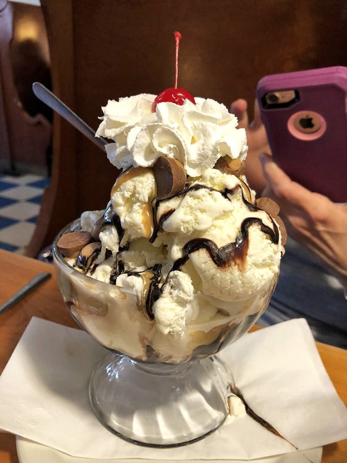 Ice cream architecture at its finest—layers of sweet engineering topped with a cloud of whipped cream that defies both gravity and restraint.