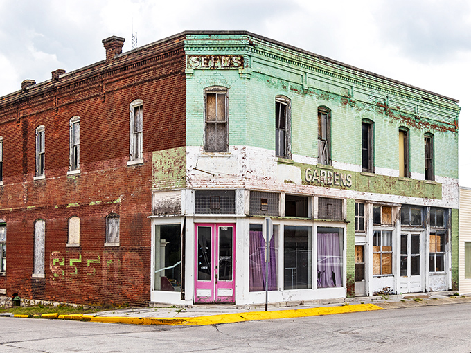 The faded "Seeds" and "Gardens" signs on this weathered storefront tell a story of agricultural dreams and small-town commerce that time hasn't completely erased.