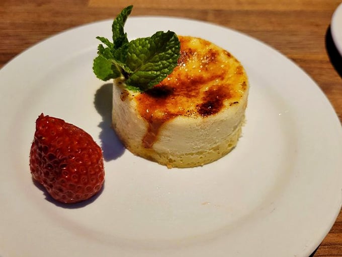 Crème brûlée cheesecake with a strawberry sidekick—dessert diplomacy at its finest as two classics form a delicious alliance.