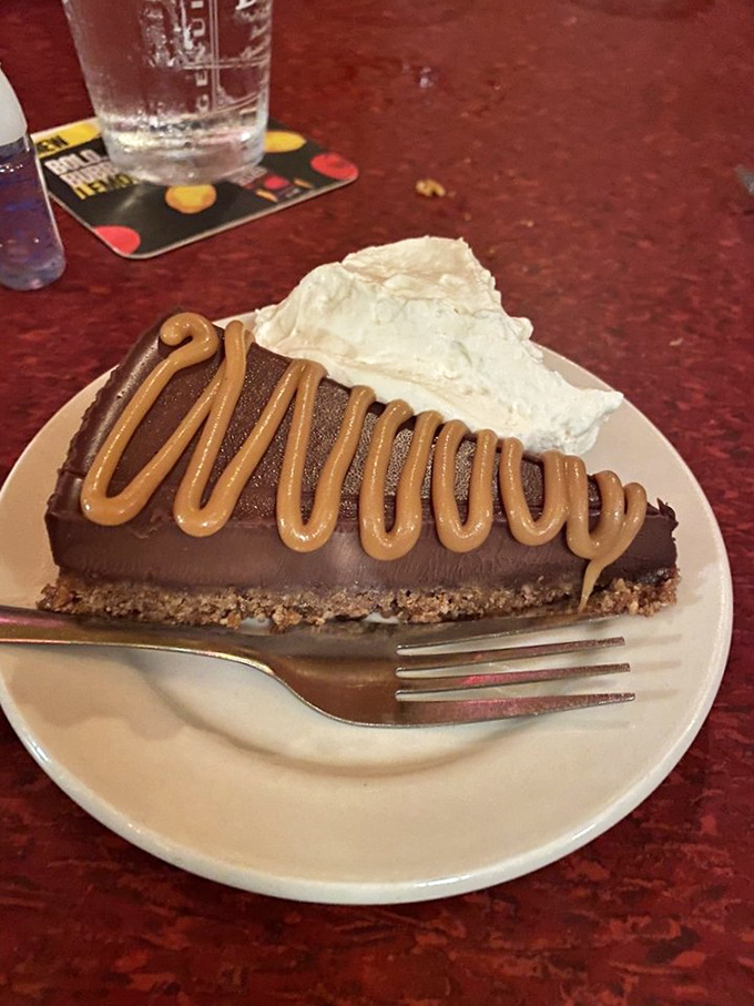 Chocolate tart with caramel drizzle—proof that geometry and dessert are perfect partners. That whipped cream isn't decoration; it's essential balance to the richness.