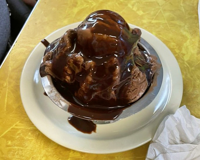 Hot fudge performs its slow, hypnotic dance over chocolate ice cream—a performance that deserves a standing ovation but usually gets a satisfied sigh.
